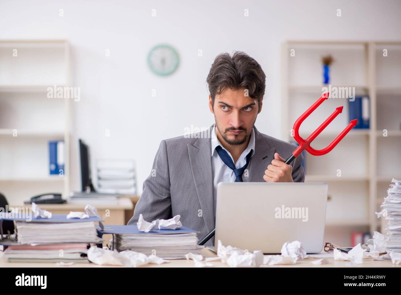 Young employee and too much work in the office Stock Photo - Alamy