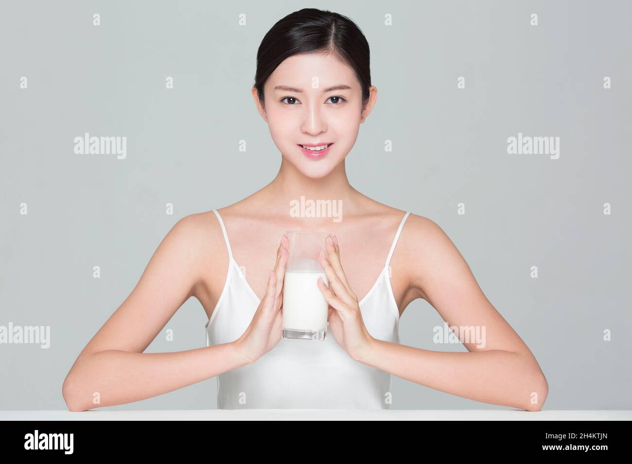 Beautiful young woman drinking milk Stock Photo - Alamy