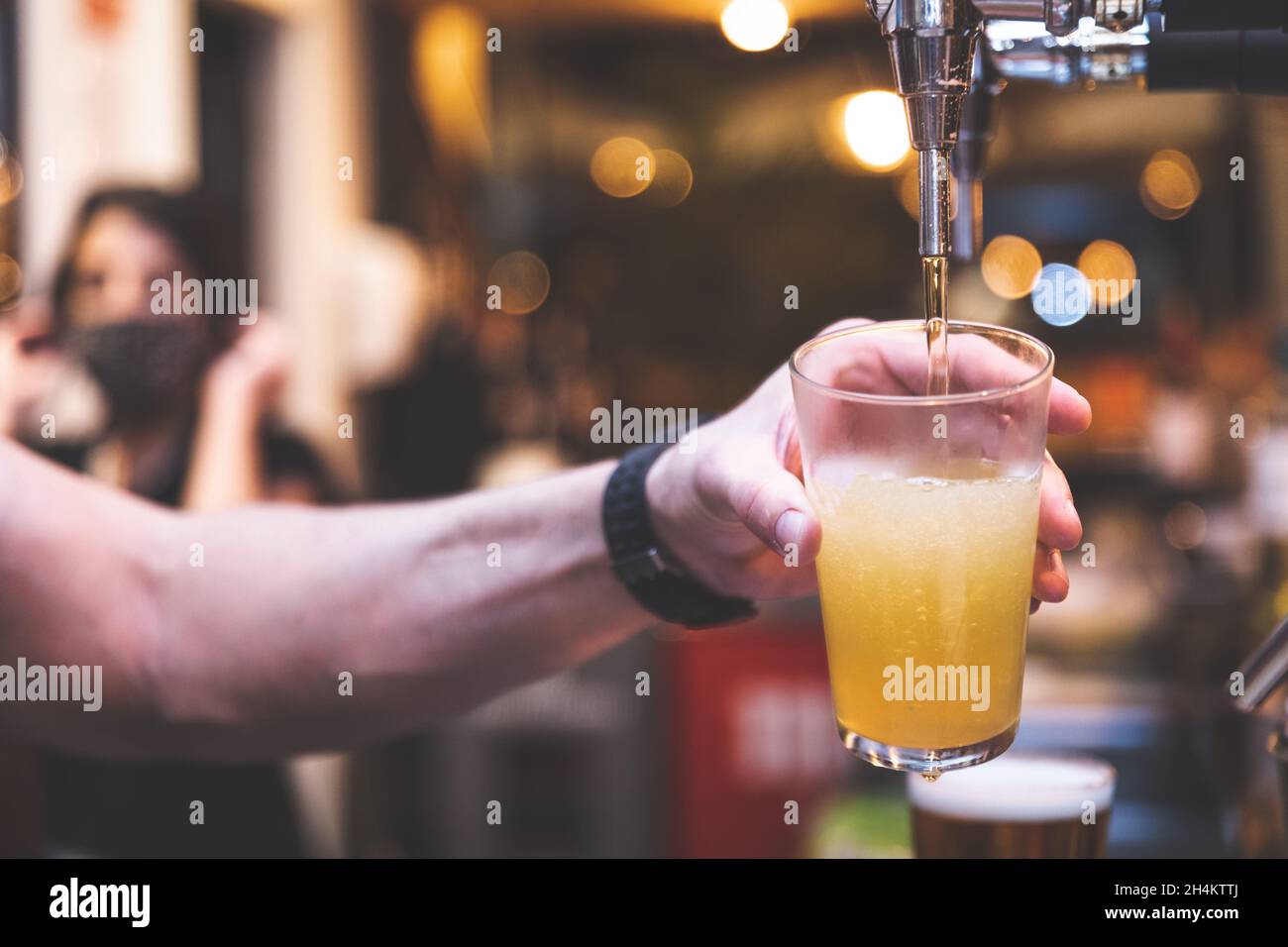 Waiter serving beer in a glass with a beer shooter at a bar Stock Photo ...