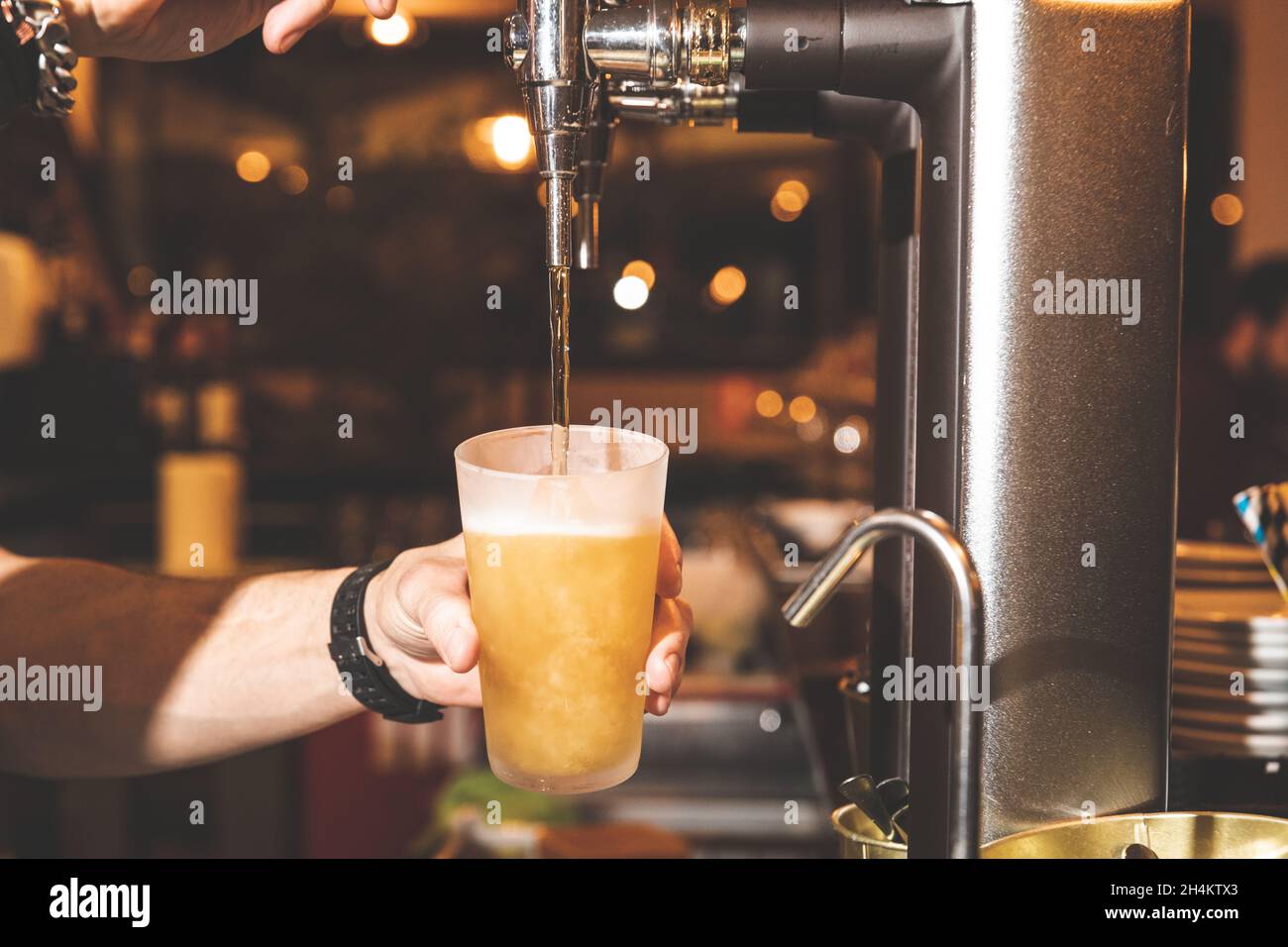 Waiter serving beer in a glass with a beer shooter Stock Photo - Alamy