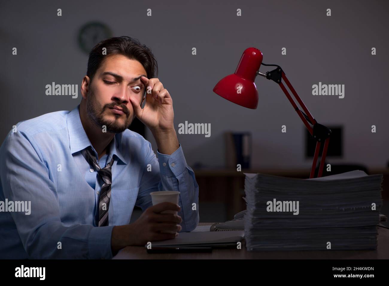 Young employee working late in the office Stock Photo - Alamy