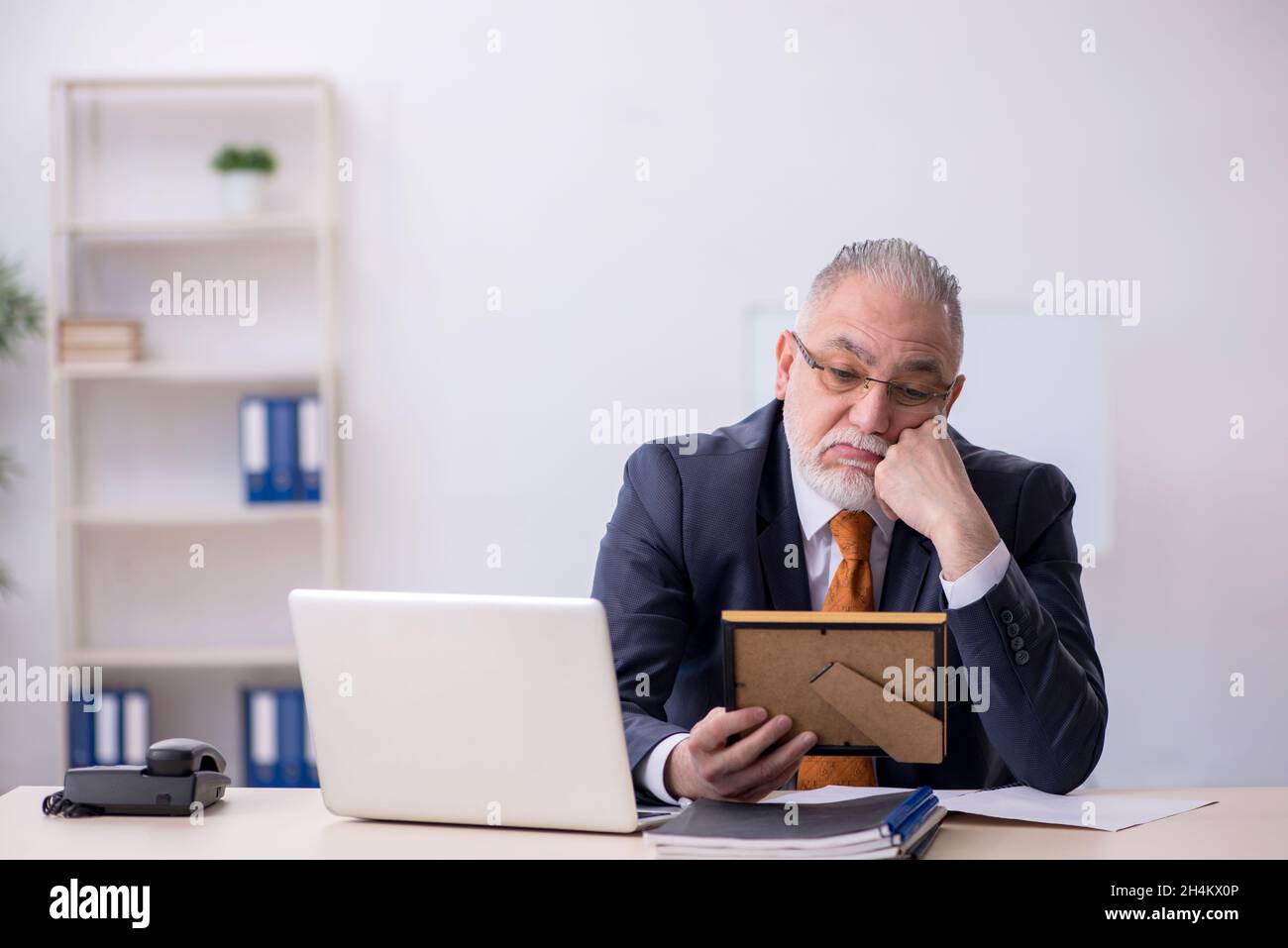 Old businessman employee missing his wife at workplace Stock Photo - Alamy