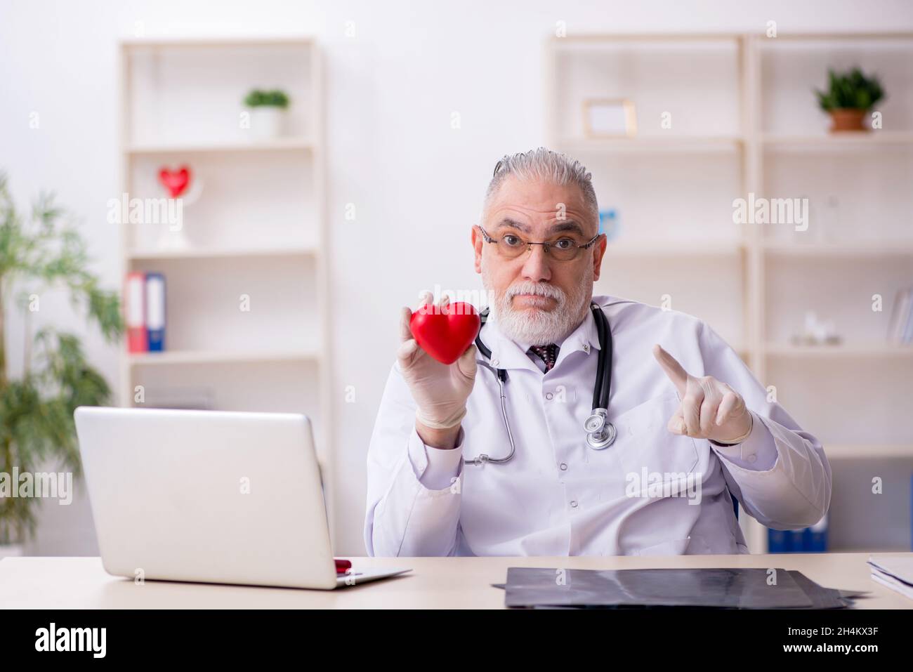 Old doctor cardiologist working in the clinic Stock Photo - Alamy