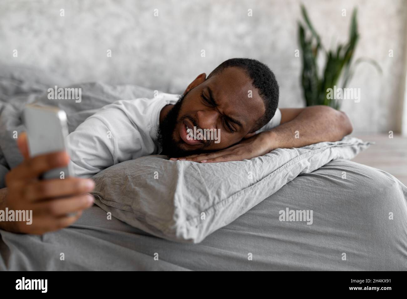 Bad News And Oversleep. Shocked confused black man wakes up with ...