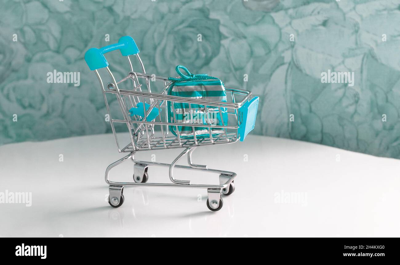 beautiful turquoise gifts with ribbon in a basket on a white table and ...