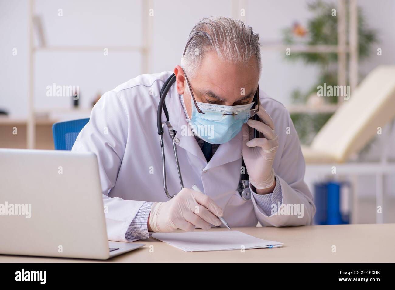 Old doctor working in the clinic Stock Photo - Alamy