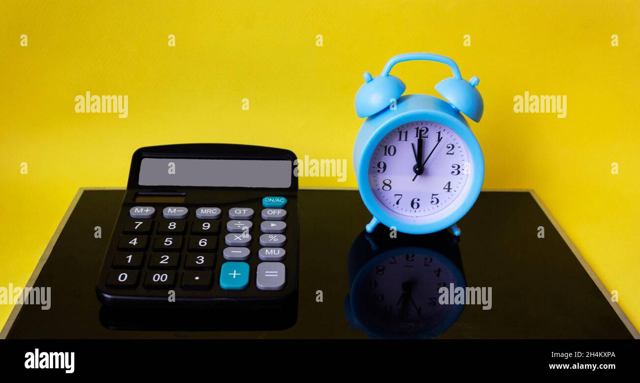 Calculator and alarm clock on black and yellow background business ...