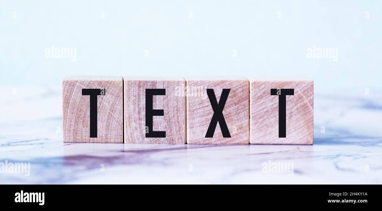 The word TEXT is written on wooden blocks and a light background Stock ...