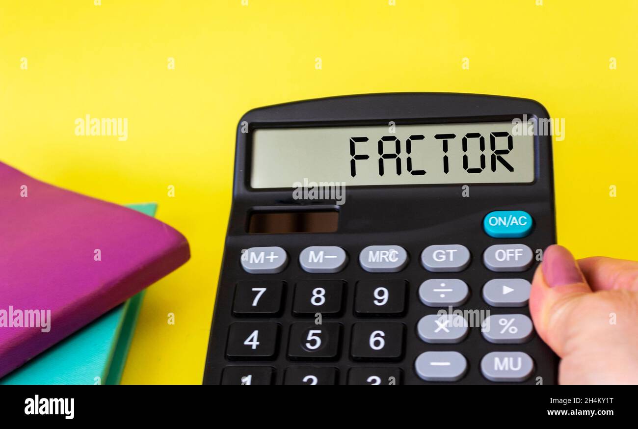 Factor, text on calculator and multicolored notepads on yellow ...