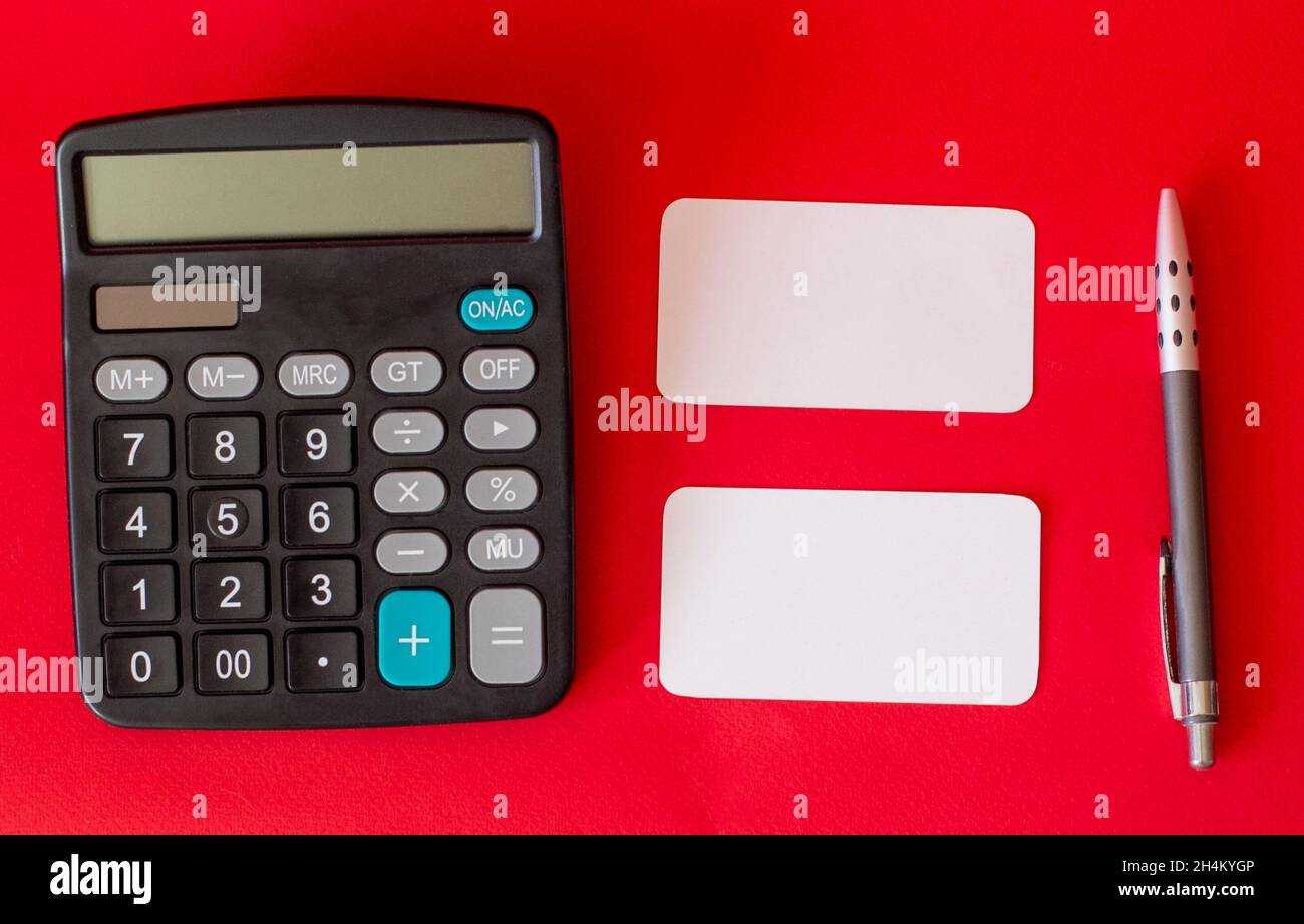 on a red background calculator, pen and business cards Stock Photo - Alamy