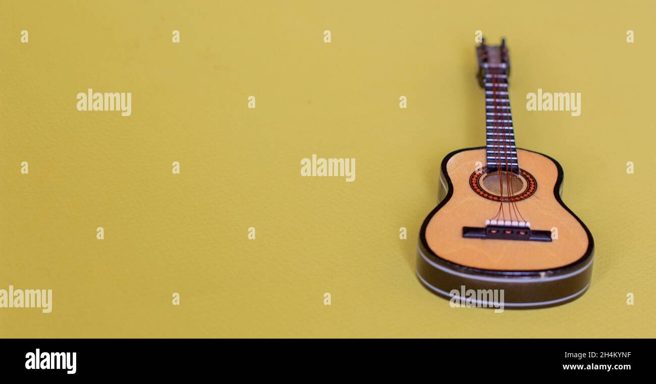 Guitar musical instrument on a yellow background Stock Photo - Alamy
