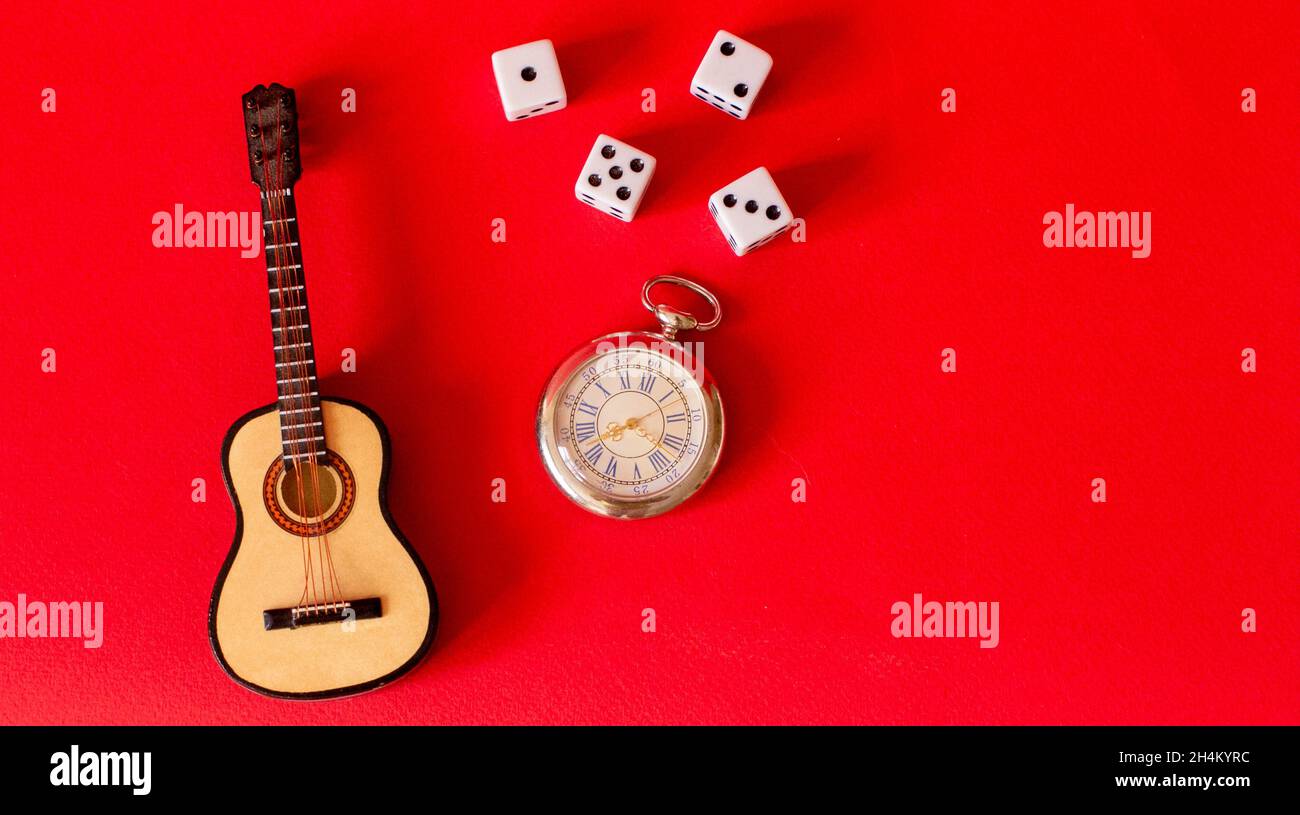 guitar, dice and clock on a red background Stock Photo - Alamy