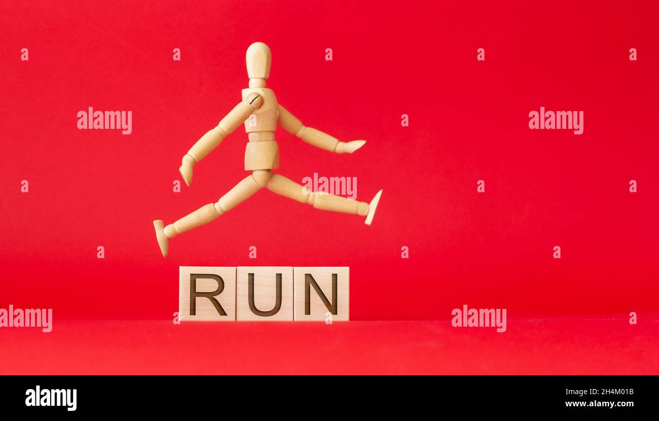 running doll on a red background with wooden cubes Stock Photo - Alamy