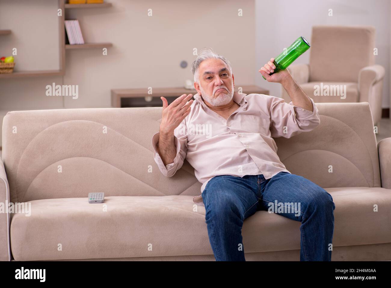 Aged man drinking alcohol at home Stock Photo - Alamy