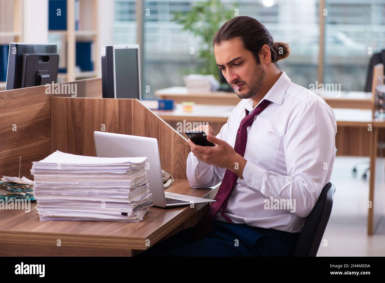 Young employee and too many work in the office Stock Photo - Alamy