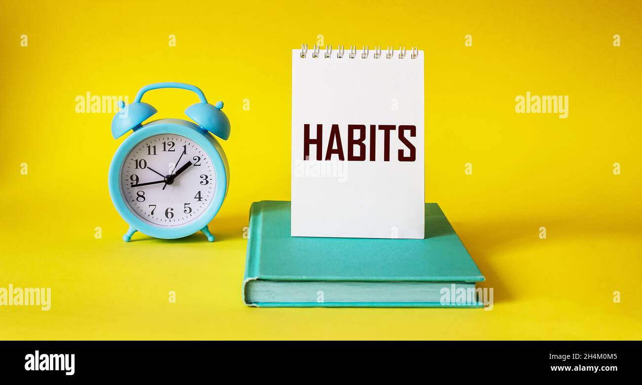 Habits word written on notepad and yellow background Stock Photo - Alamy