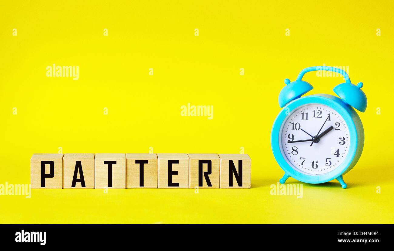 The word PATTERN is written on wooden blocks and on a yellow background ...