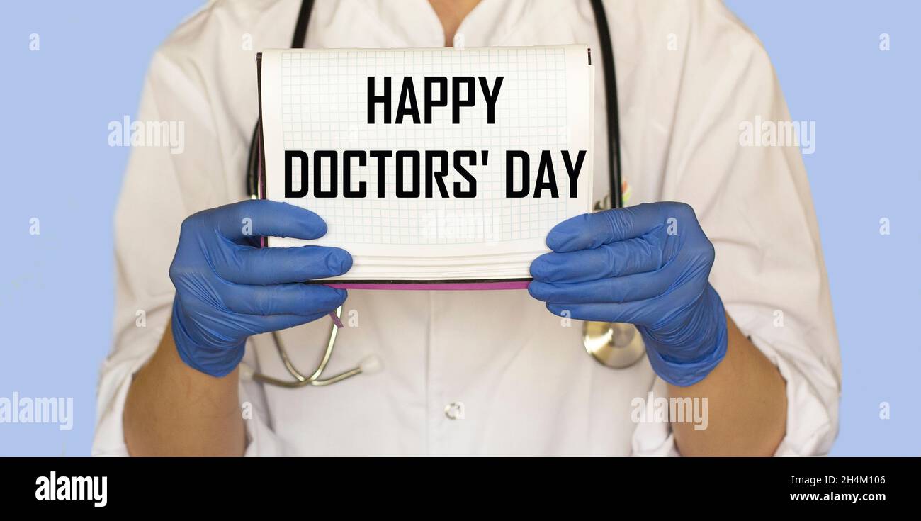 Doctor concept. The doctor is holding a spiral notepad that says HAPPY ...