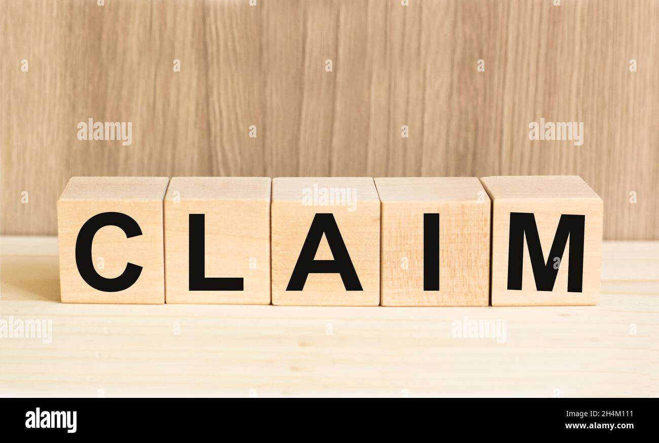 claim word written on wood block. claims text on wooden table for your ...