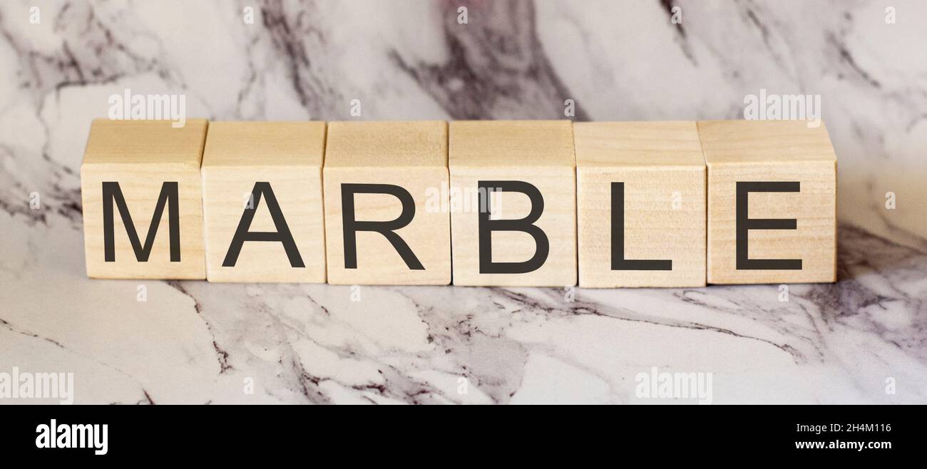 The word marble on cubes on a gray marble background. Business concept ...