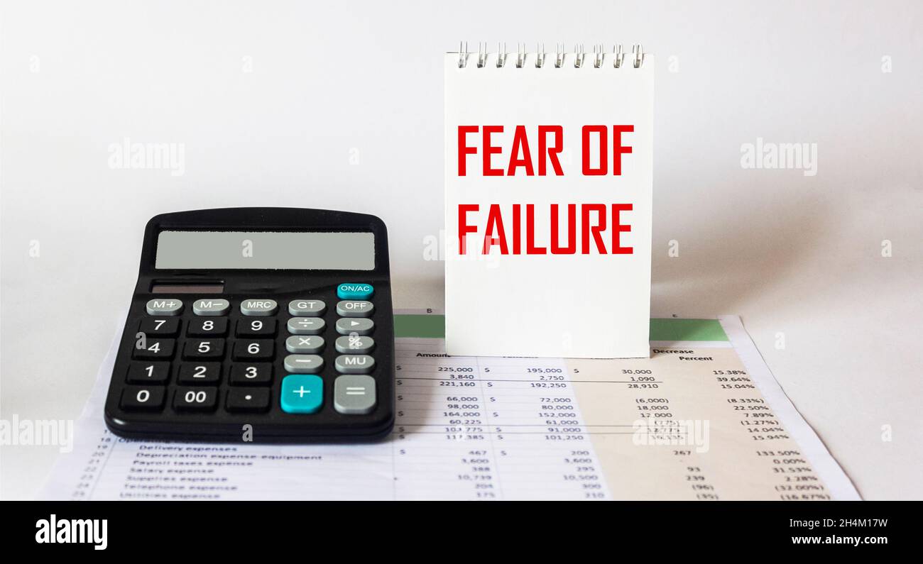 fear of failure text on white card lying next to calculator and ...