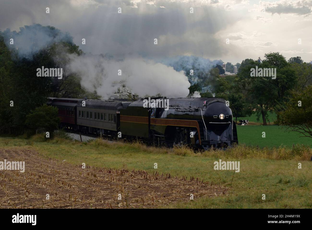 An Antique Steam Engine Approaching With Passenger Coaches on an ...