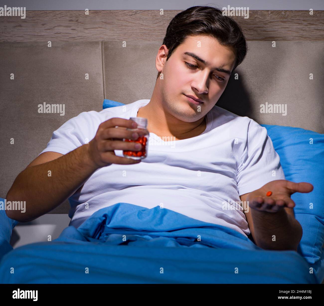 The man taking medical pills from insomnia Stock Photo - Alamy