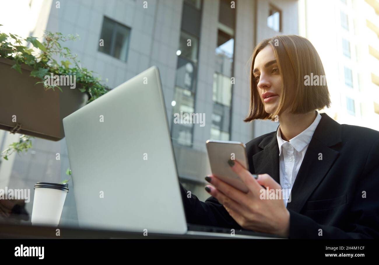 Self-confident motivated young freelance woman, copywriter using mobile ...