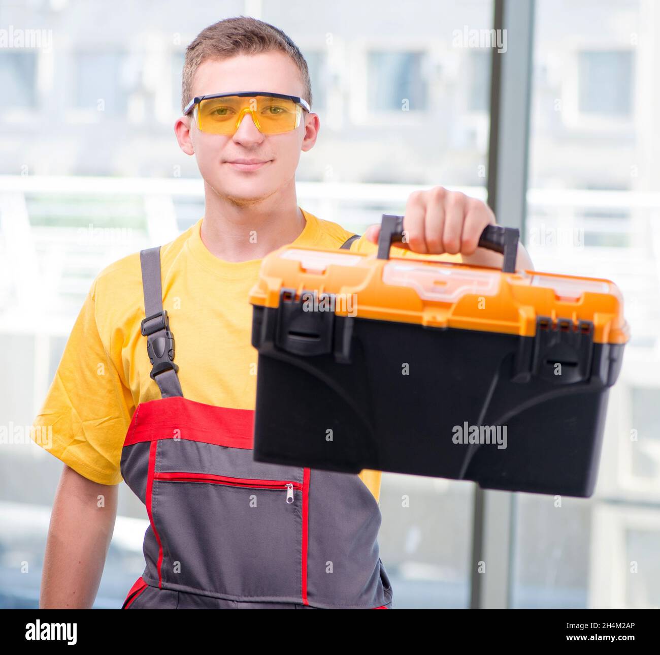 The young construction worker in yellow coveralls Stock Photo - Alamy