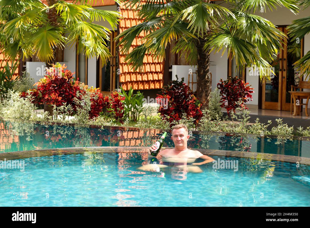 A caucasian enjoying beer in the swimming pool Stock Photo - Alamy