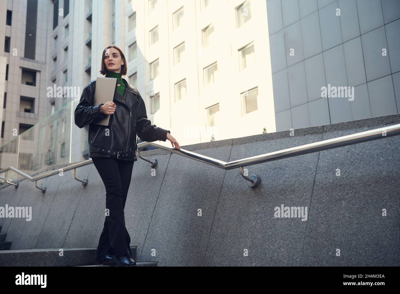 Self-confident motivated successful woman freelancer walking down the ...