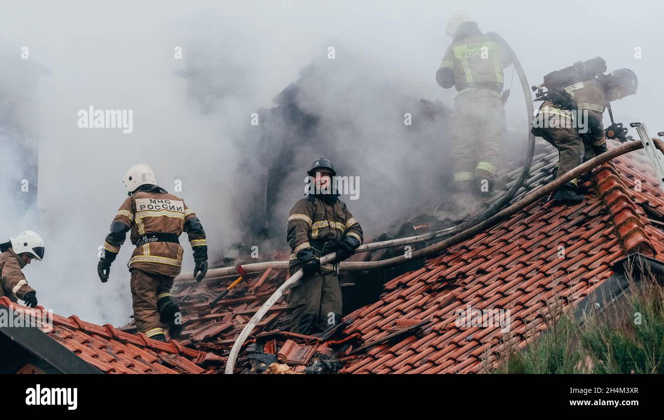 Firefighters are fighting a fire on the roof of a mansion. Firefighter ...