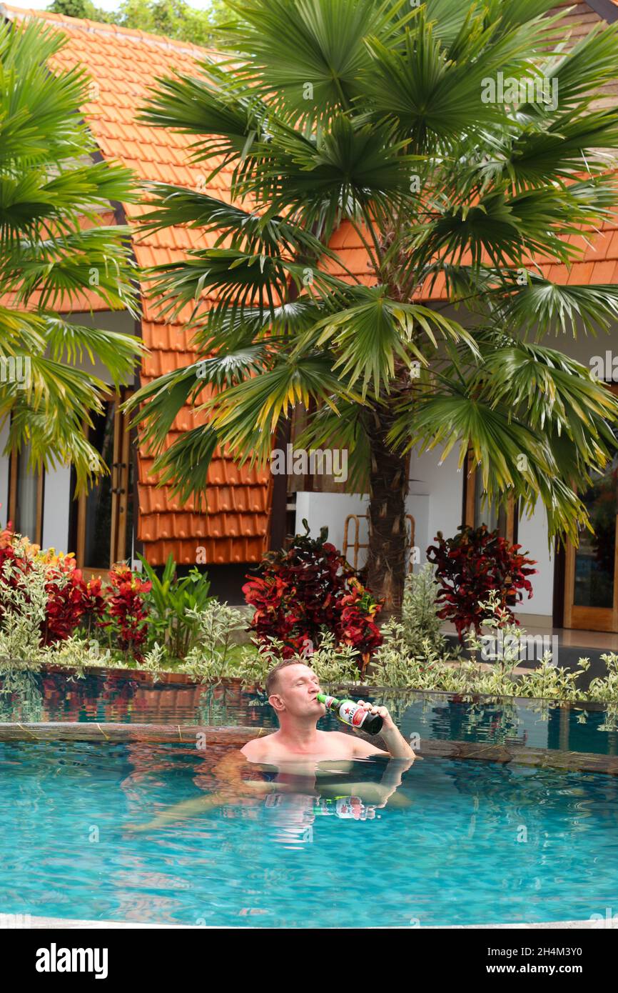A caucasian enjoying beer in the swimming pool Stock Photo - Alamy
