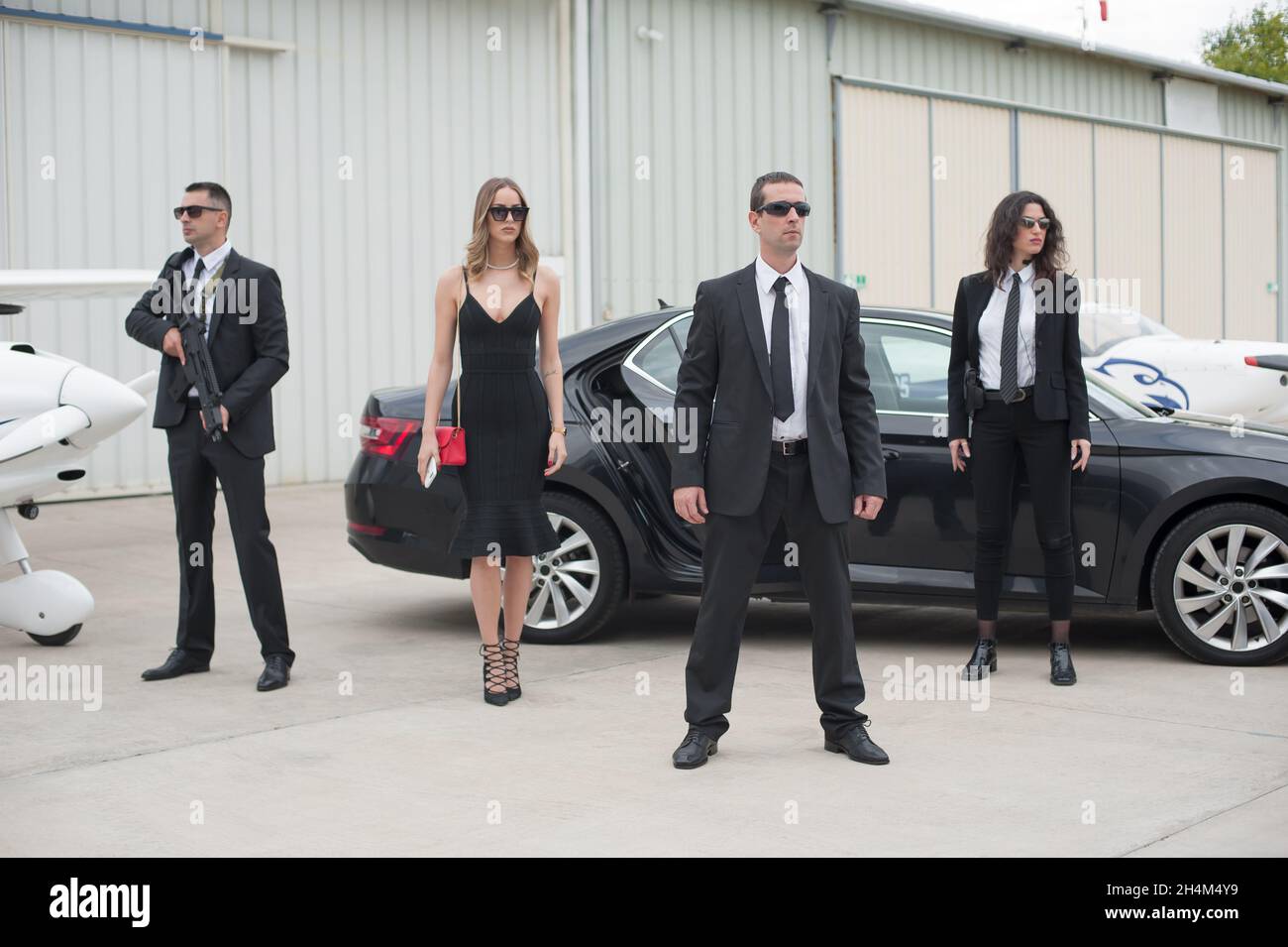Professional team of female and male bodyguards protect famous VIP ...