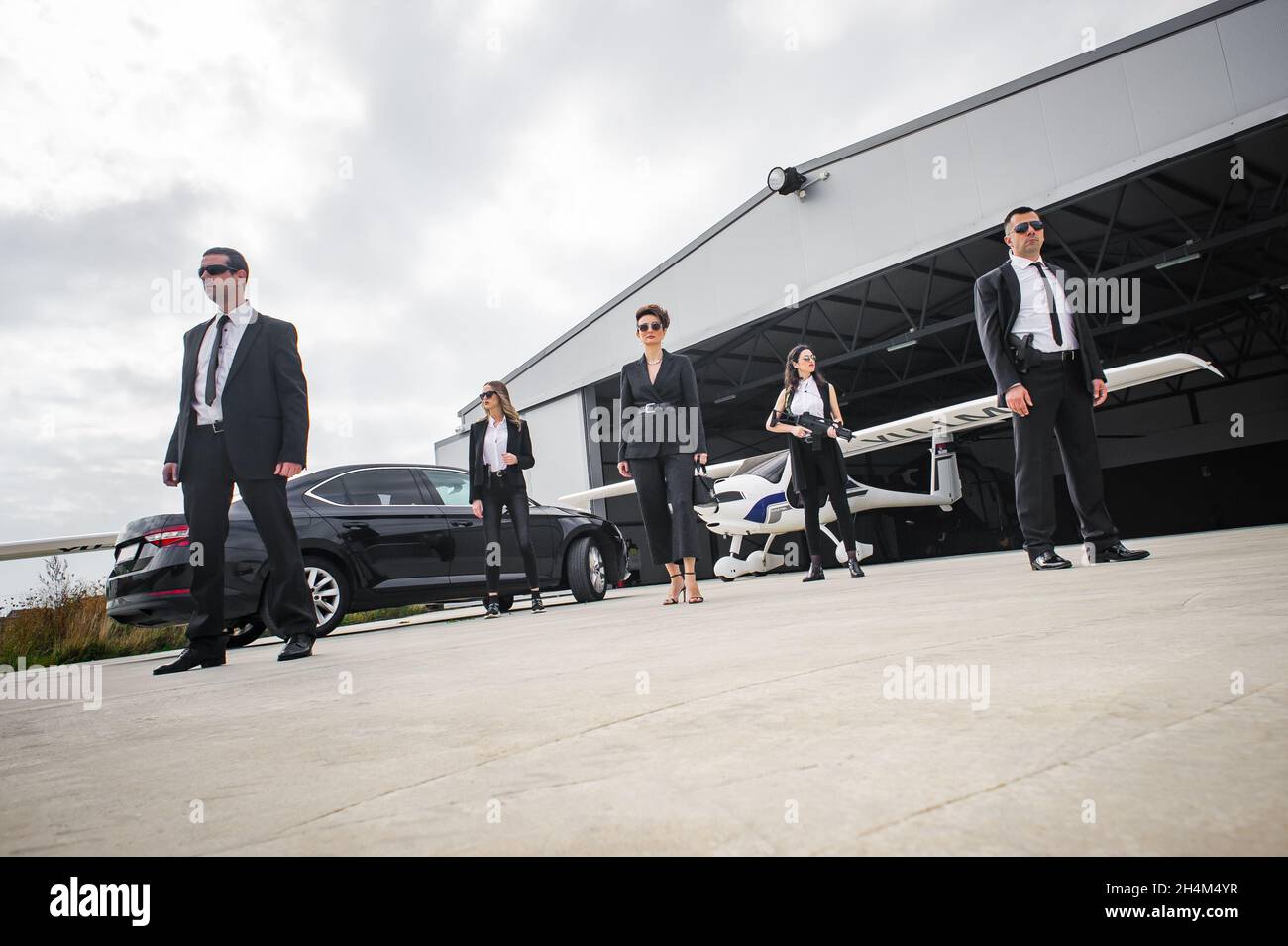 Professional team of female and male bodyguards protect famous VIP ...