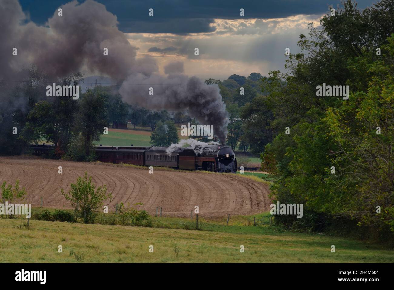 An Antique Steam Engine Approaching With Passenger Coaches on an ...