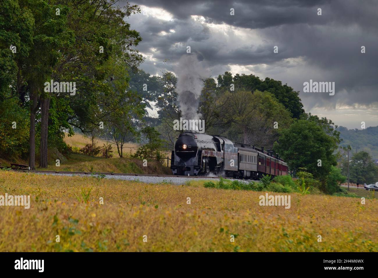 An Antique Steam Engine Approaching With Passenger Coaches on an ...