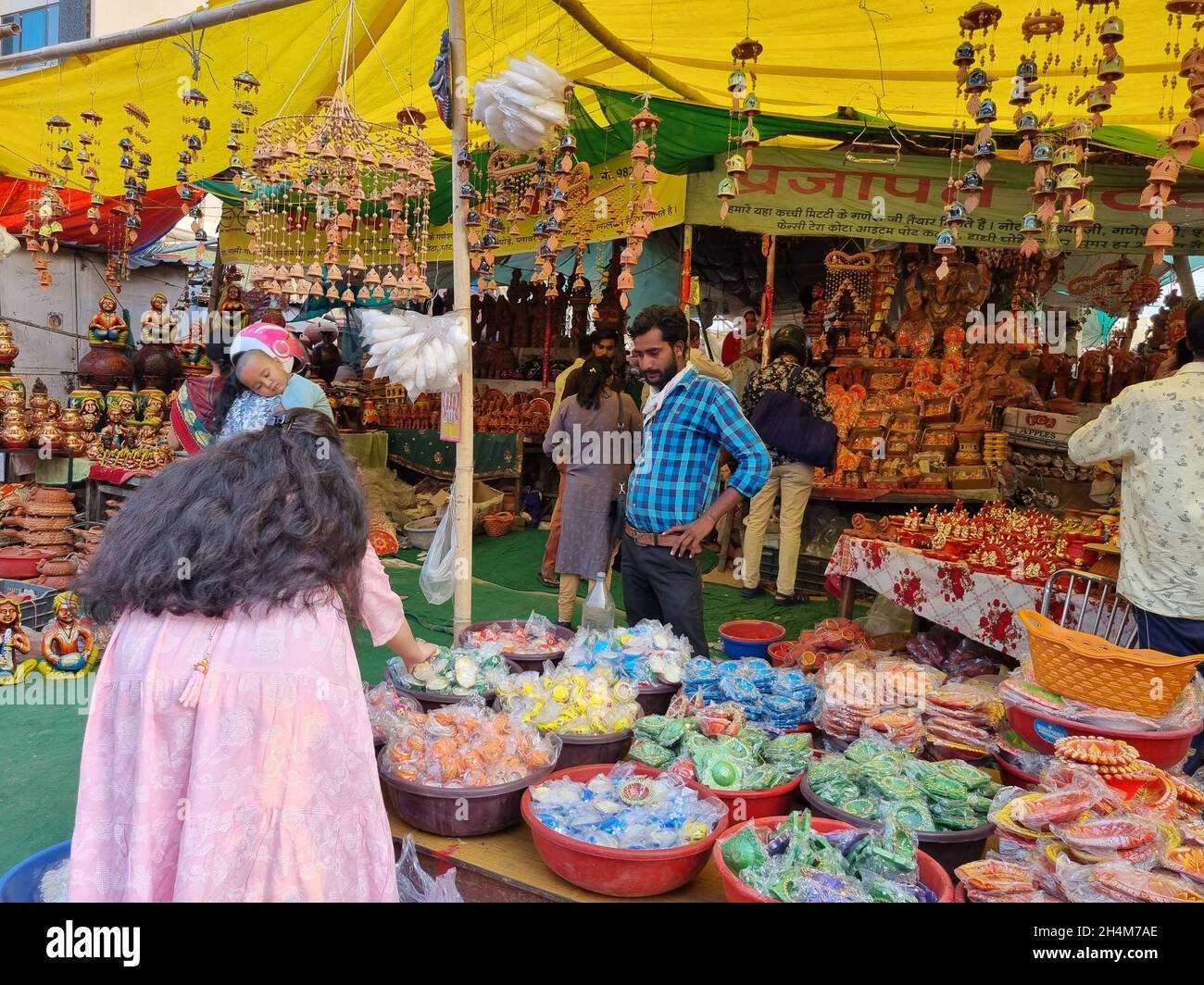 Indian girl buying colorful diya lamps made of clay earthenware from a ...