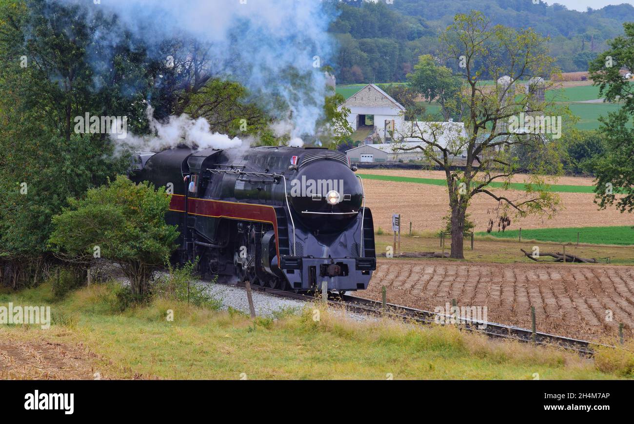 An Antique Steam Engine Approaching With Passenger Coaches on an ...