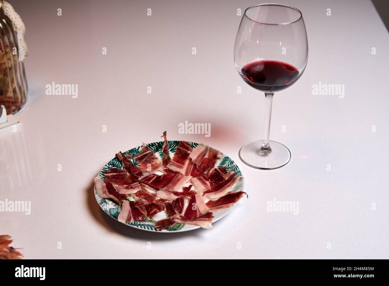 plate of typical Spanish Iberian ham cut by hand with a glass of Rioja ...