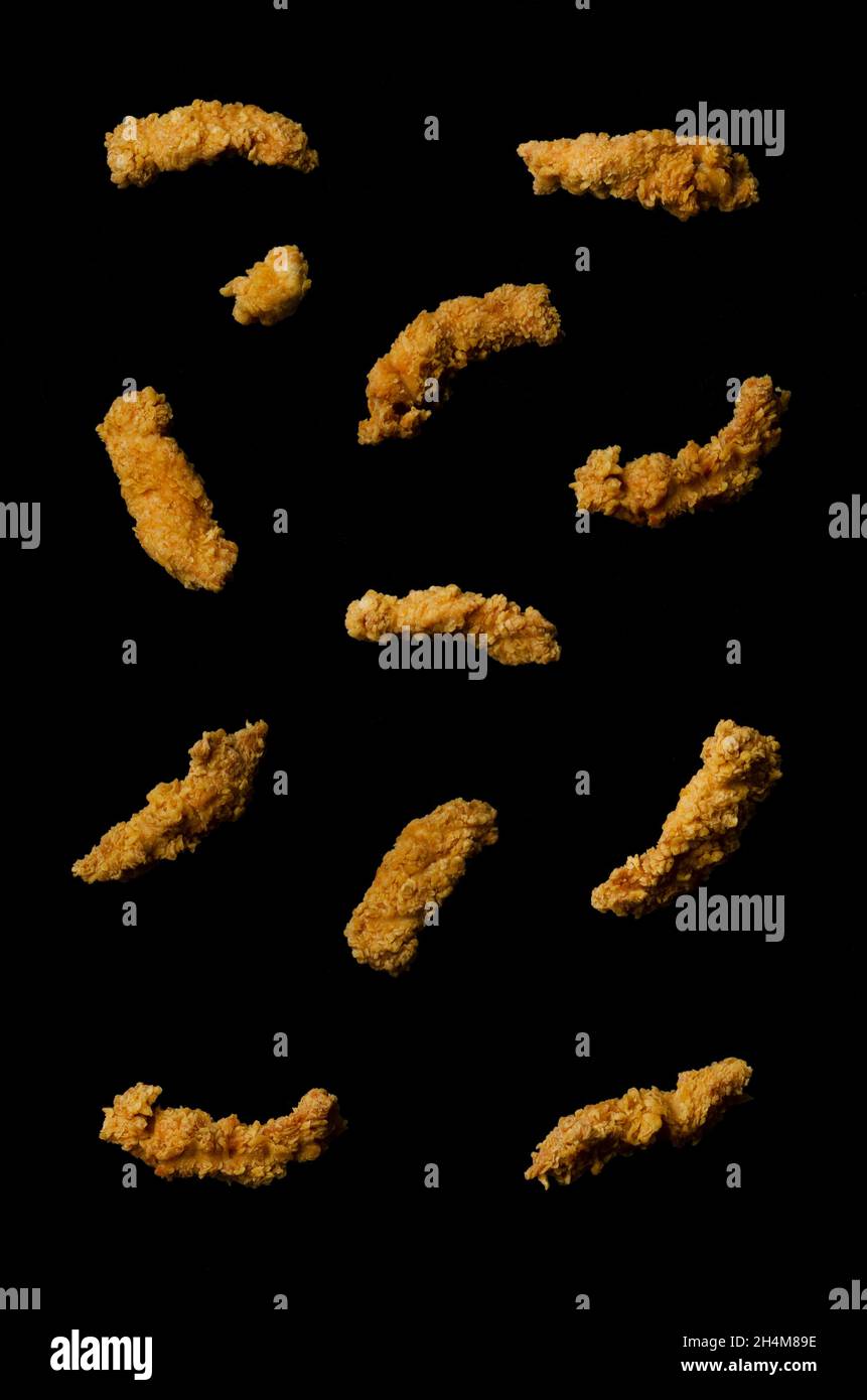 Flying chicken strips nuggets isolated on a black background Stock ...