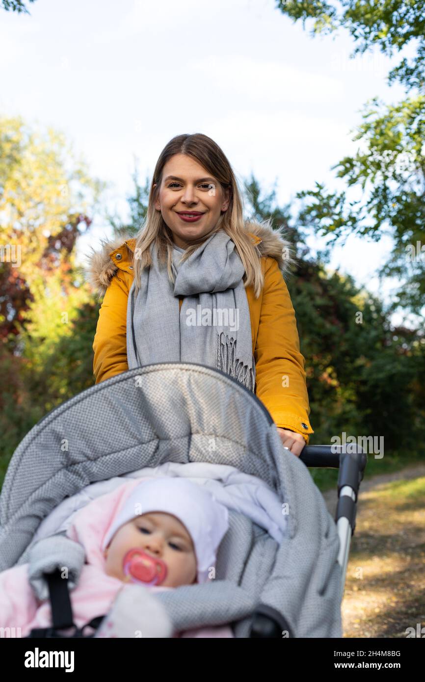 Picture of young cheerful caucasian lady walking her baby with a ...
