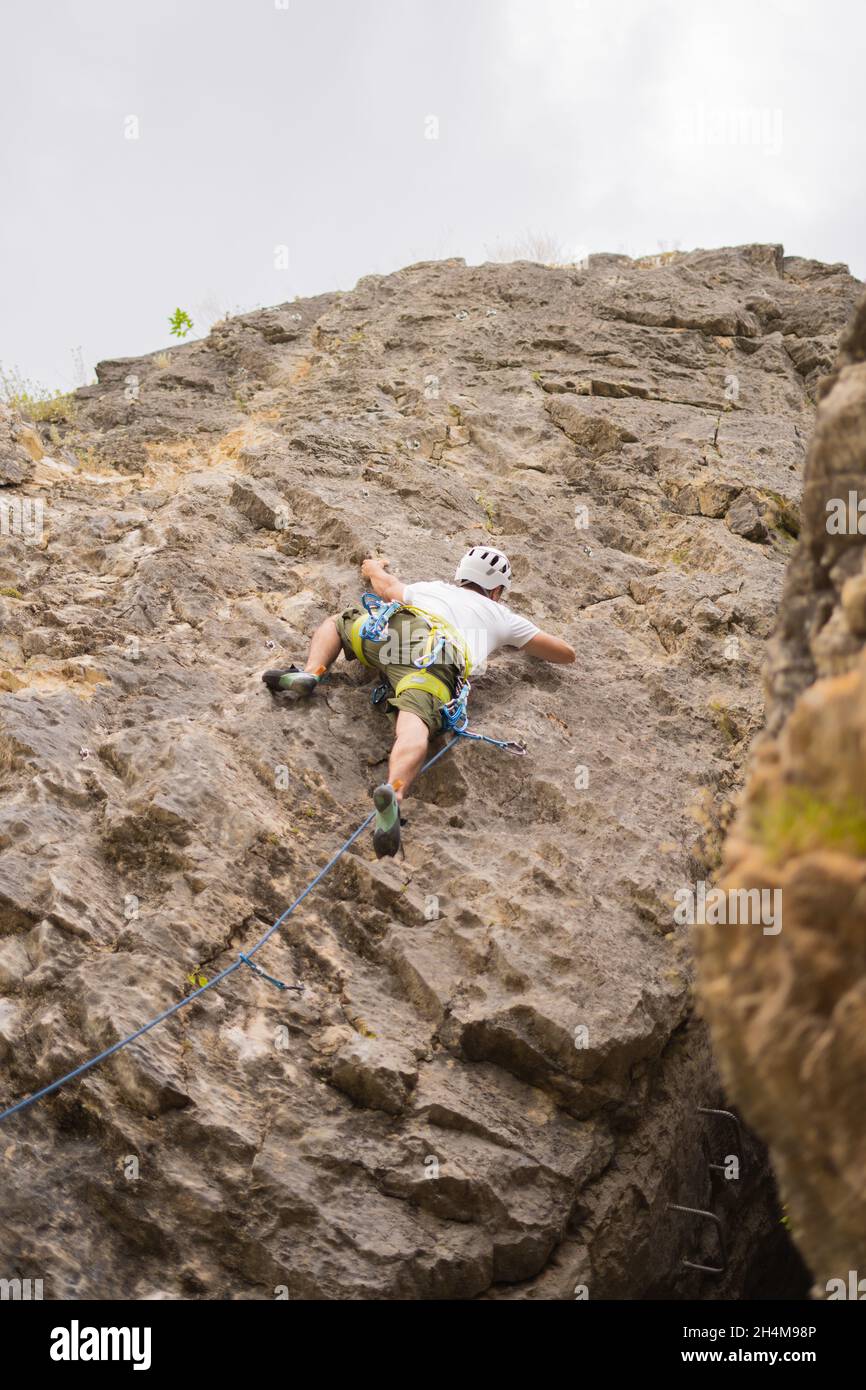 handsome youn guy is climbing and preparing the high hill Stock Photo ...