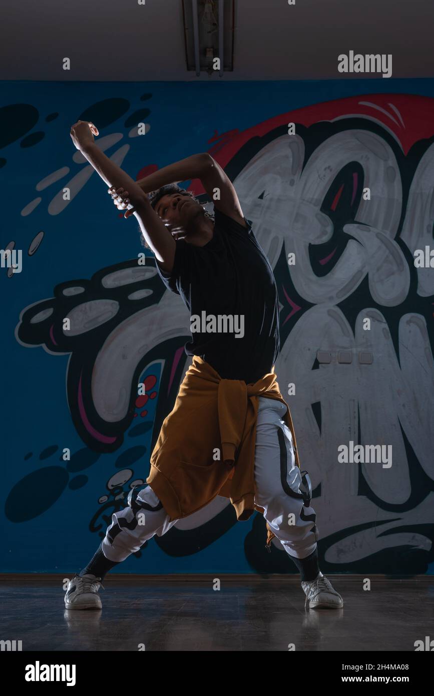 African American hip hop dancer (breakdancer) performing over graffiti ...