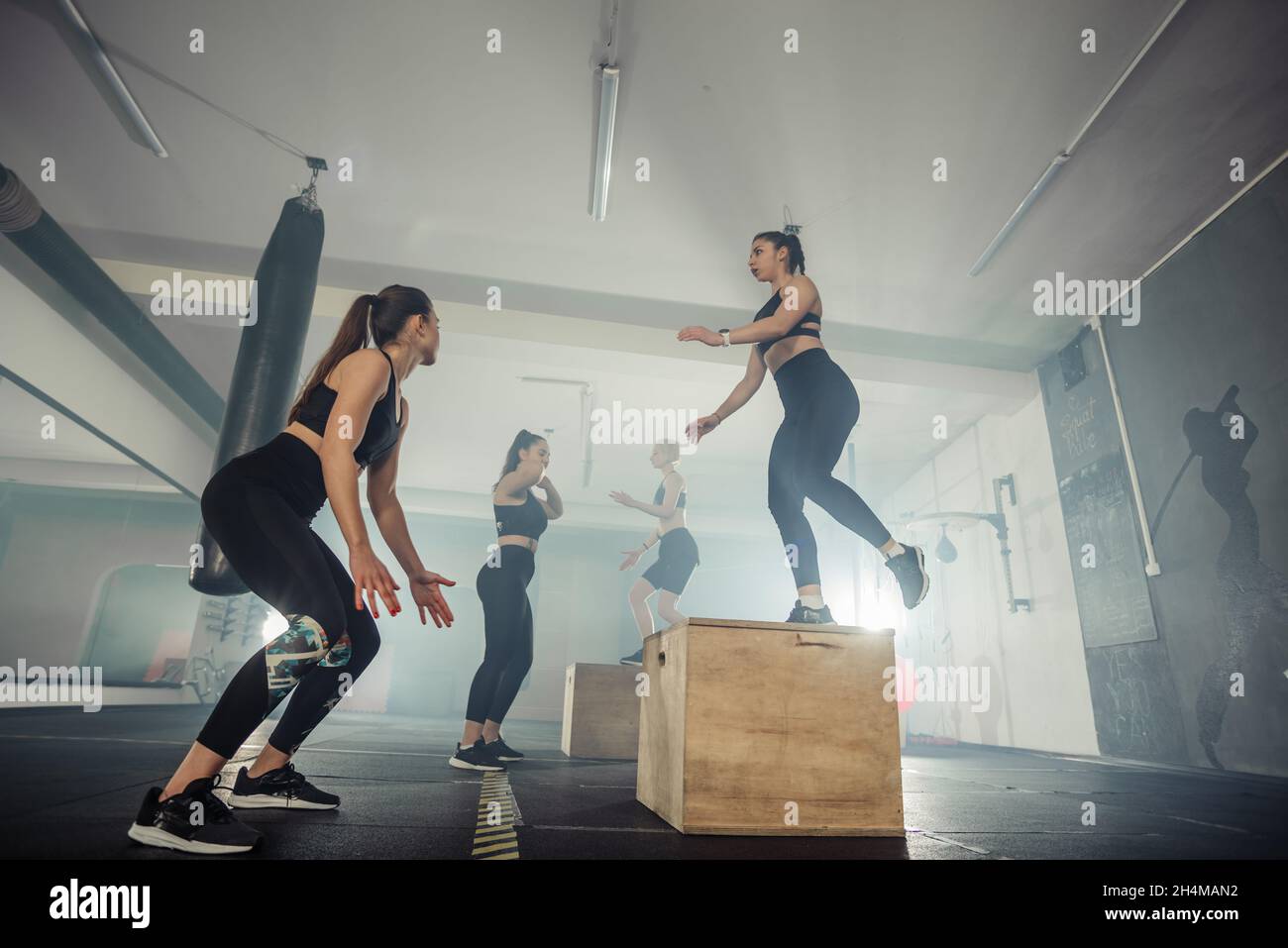 Fitness group of strong women having cross-functional training in the ...
