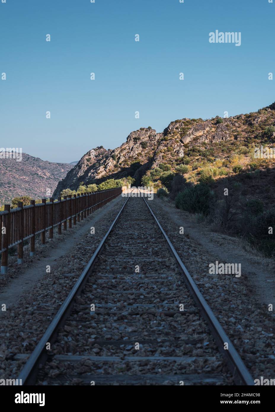 Railway track at the side of a mountain under a clear blue sky Stock ...