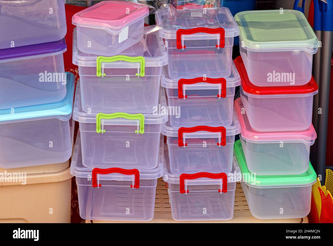 Stack of closed plastic storage containers on market stall Stock Photo ...