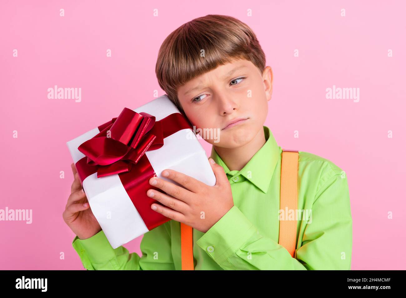 Photo of young small school boy receive gift box shake curious moody ...