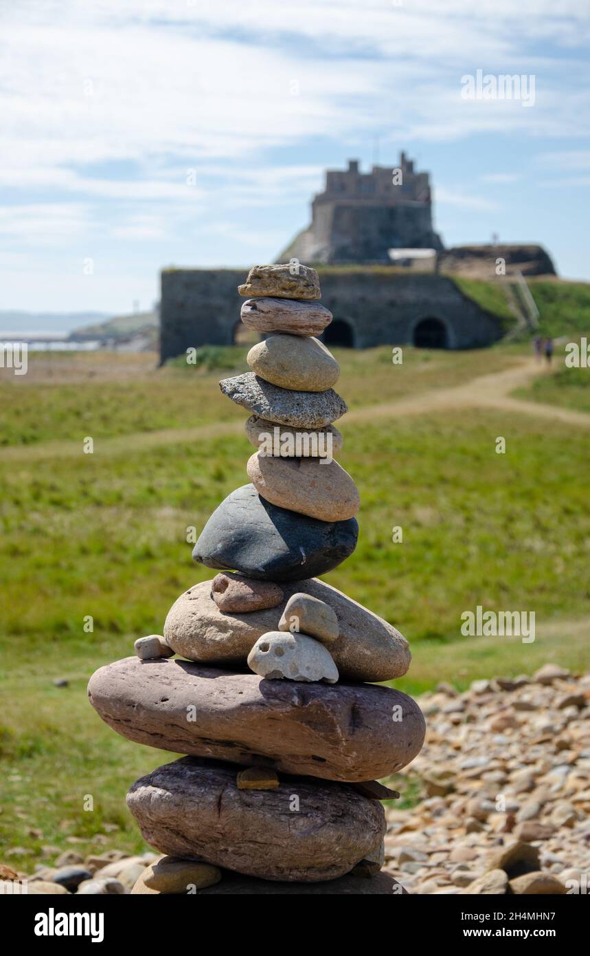 Cairns built by visitors to Lindisfarne Castle on Holy Island, off the ...