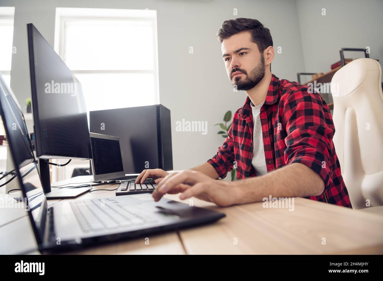 Photo of serious focused young man professional programmer look screen ...